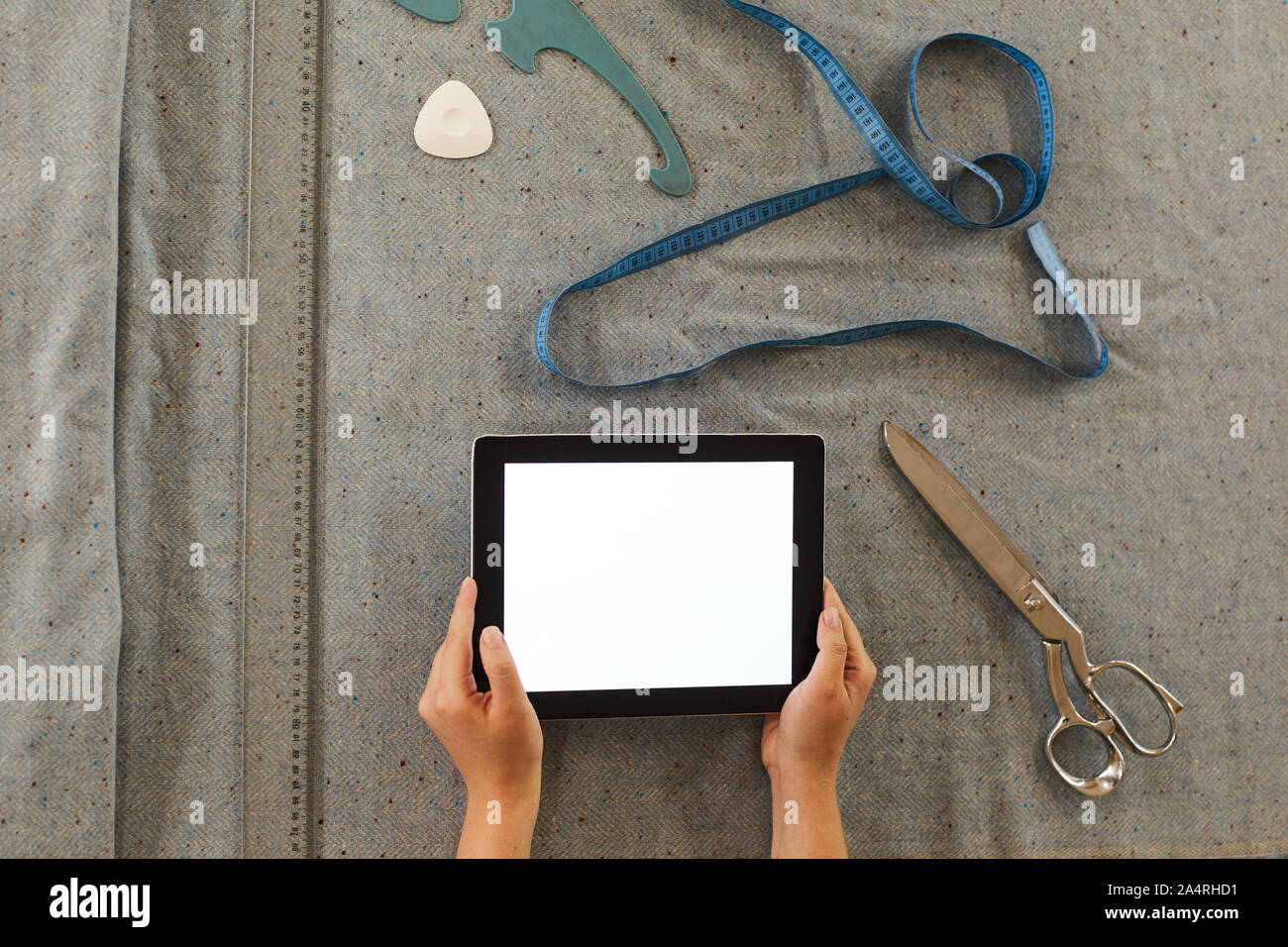 Close-up of tailor holding digital tablet and using it in her work ...