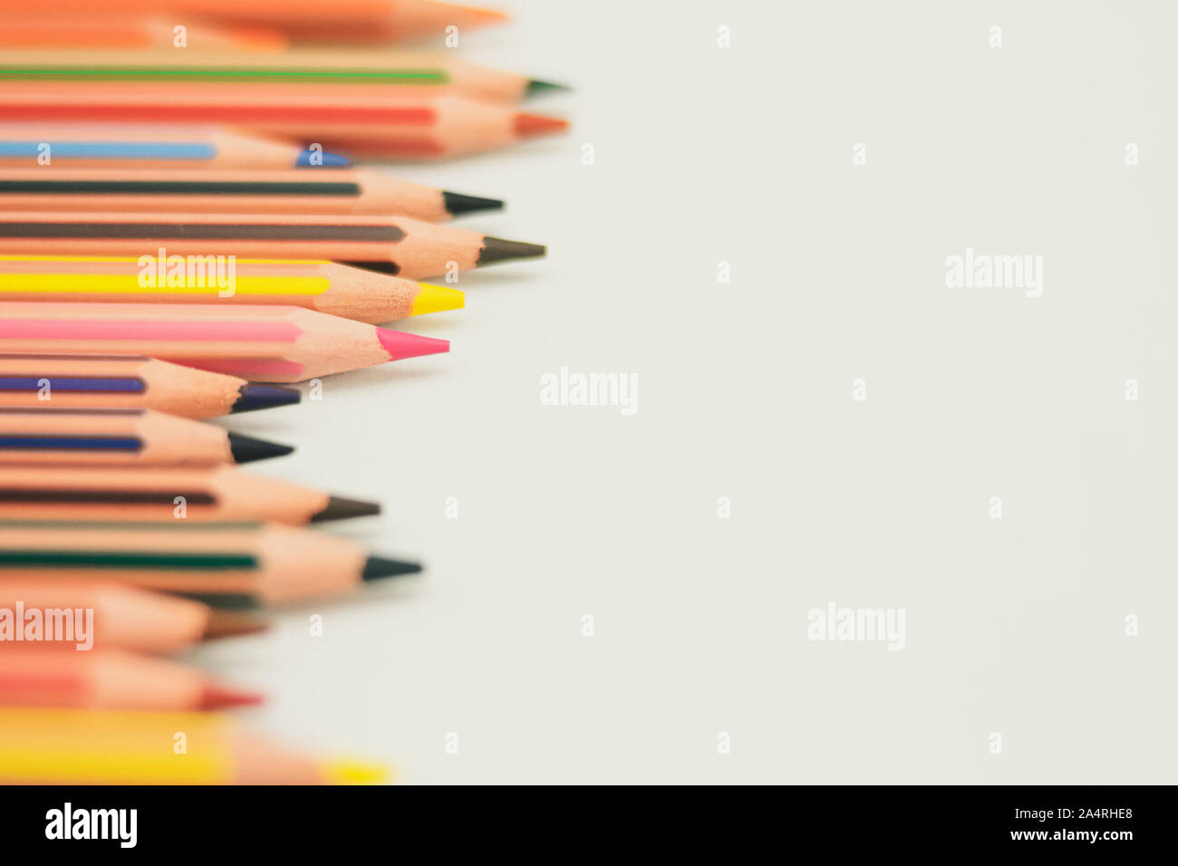 Pointy colored pencils that appear from the left side of the background ...