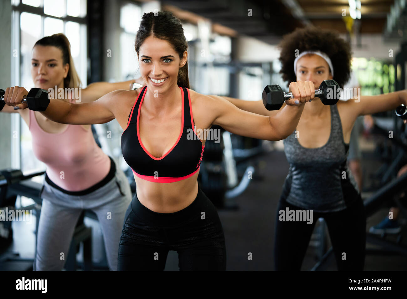 Beautiful fit people exercising together in gym Stock Photo - Alamy