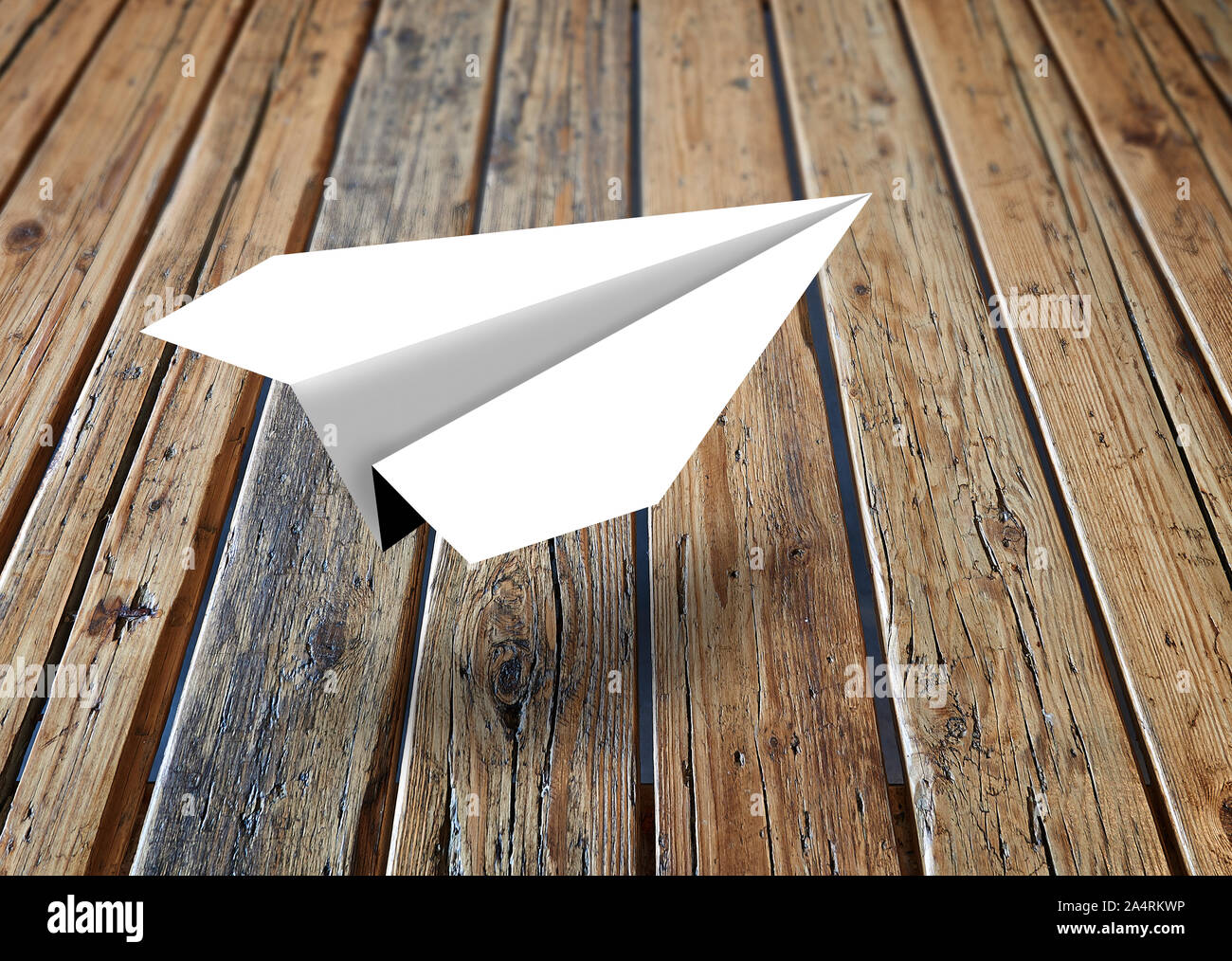 Paper plane origami flying over textured wooden table Stock Photo - Alamy
