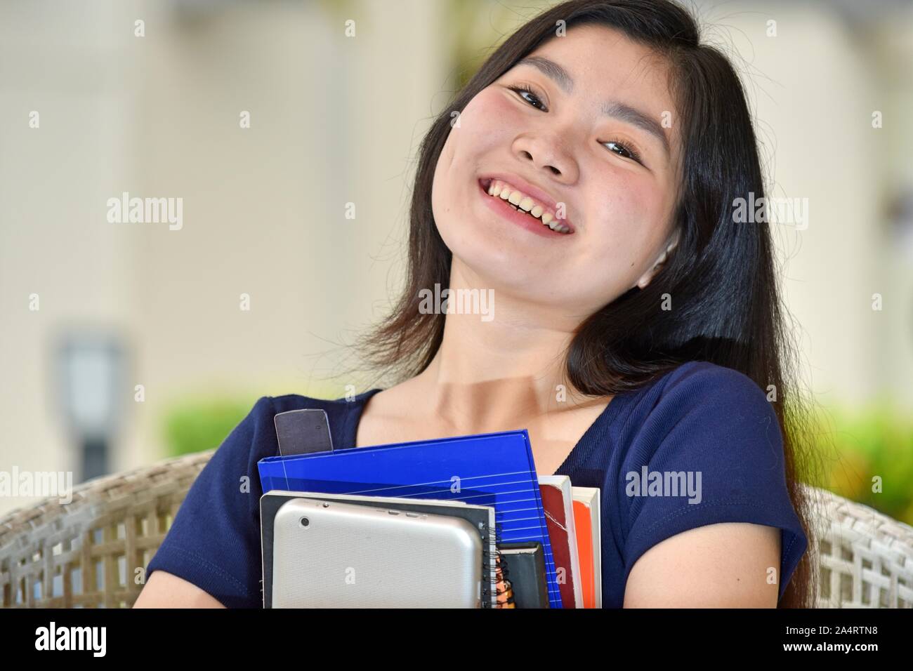 Chinese Female Student Laughing With Notebooks Stock Photo - Alamy