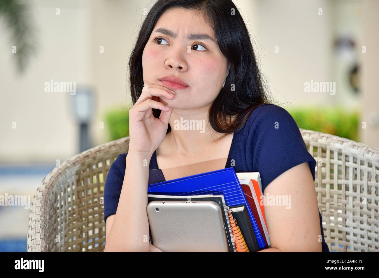 Female Student Thinking With Notebooks Stock Photo - Alamy