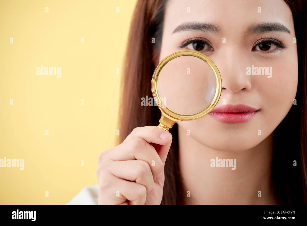 Woman with magnifying glass isolated on a yellow background Stock Photo ...