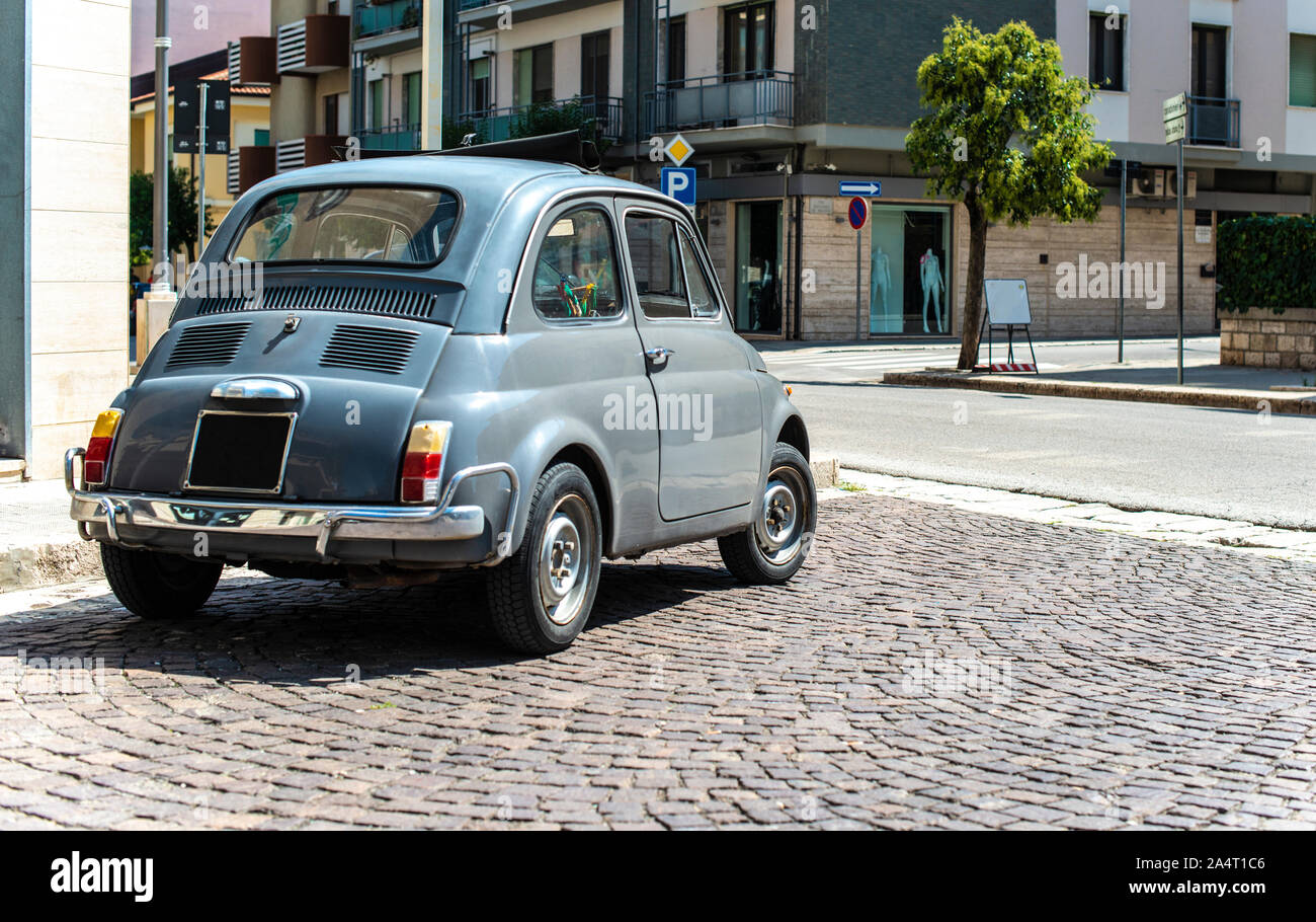 Vintage small car on traditional italian paved street. Dark grey old ...