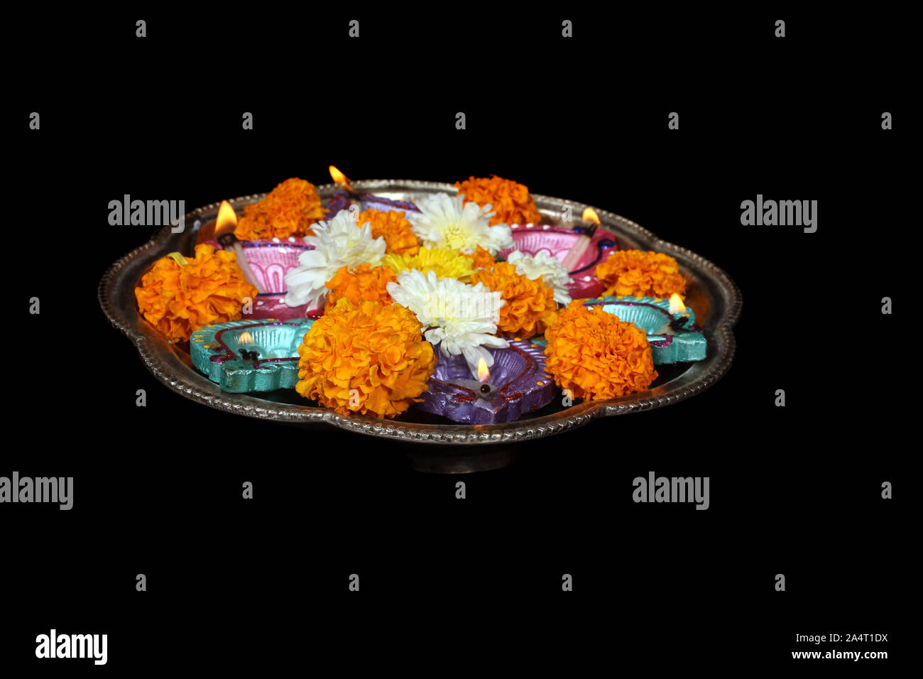 A holy plate containing flowers and lamps for a traditional Diwali ...