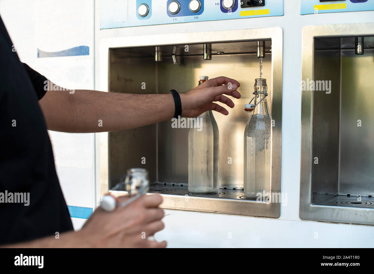 Mineral Water machine on the street. Filling mineral water bottles from ...