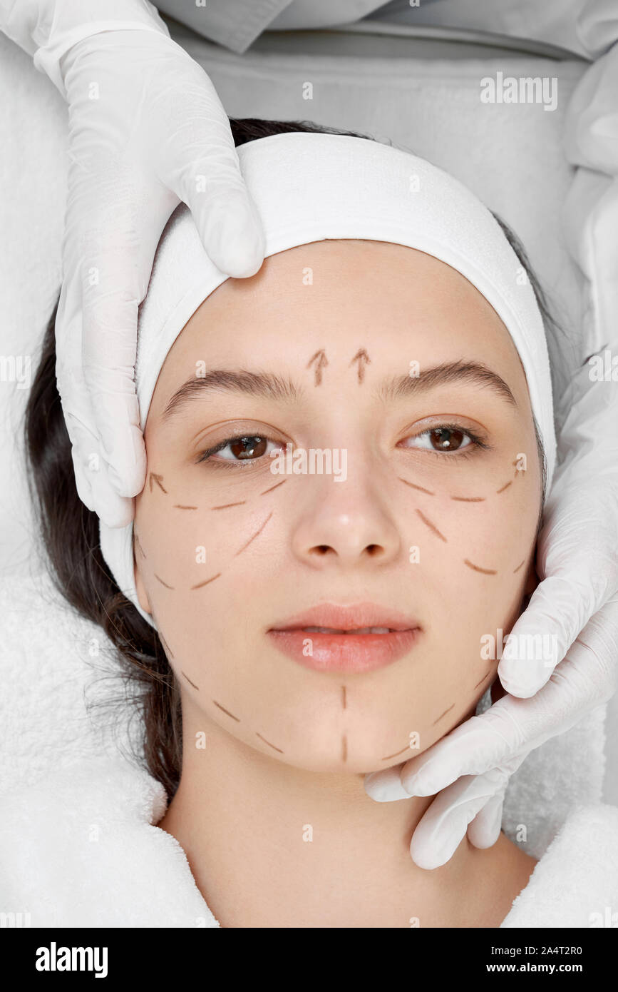 Close up of young female face with black lines. Professional ...