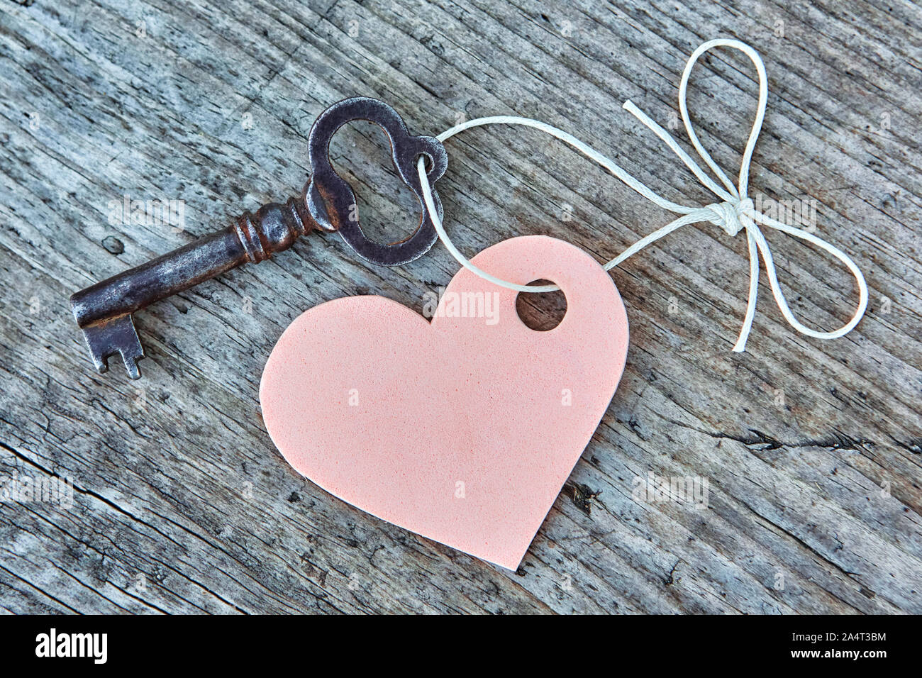 Vintage key and pink heart on a string with a bow. Valentine. Space for ...