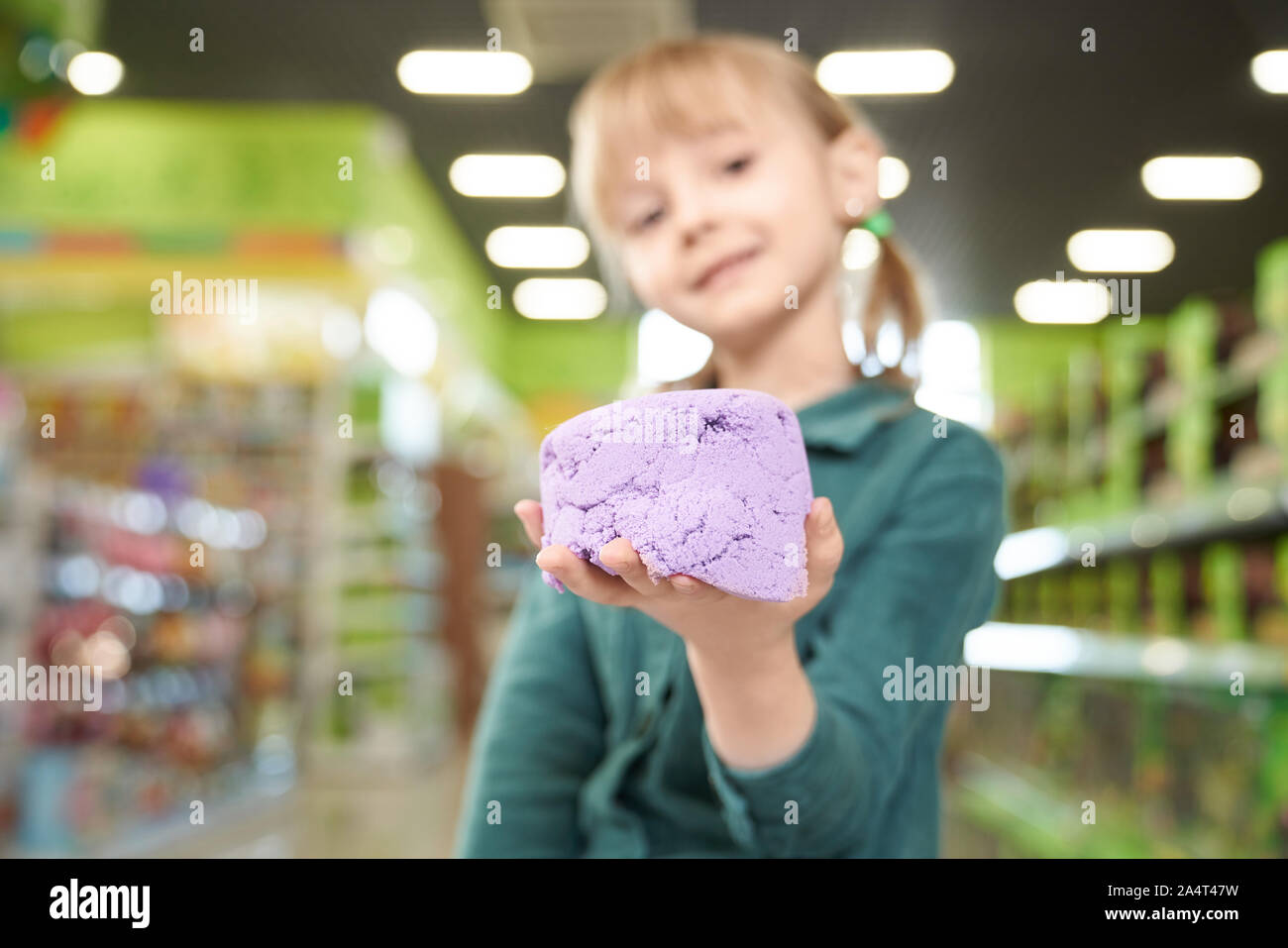 Close up of kinetic sand child showing on hand. Young, pretty girl ...