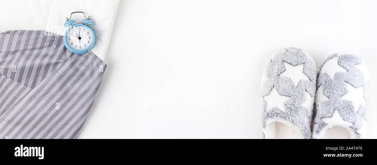 Sleep. Soft fluffy slippers and blue alarm clock isolated on white ...