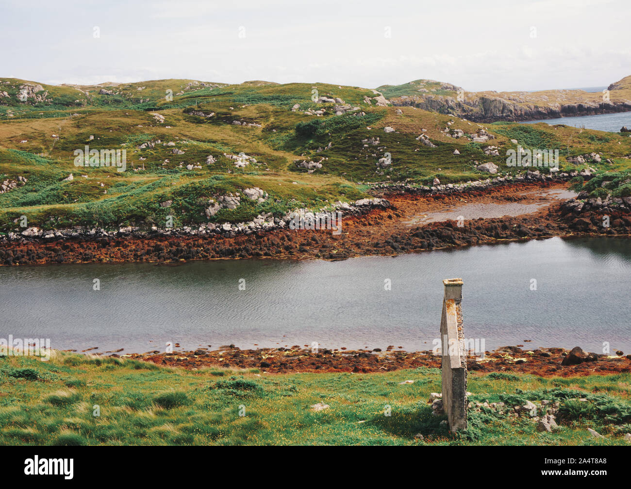 Wall of abandoned croft next to loch amongst the rugged landscape of ...