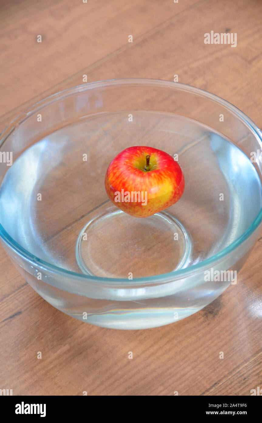 Apple floating in bowl Stock Photo - Alamy