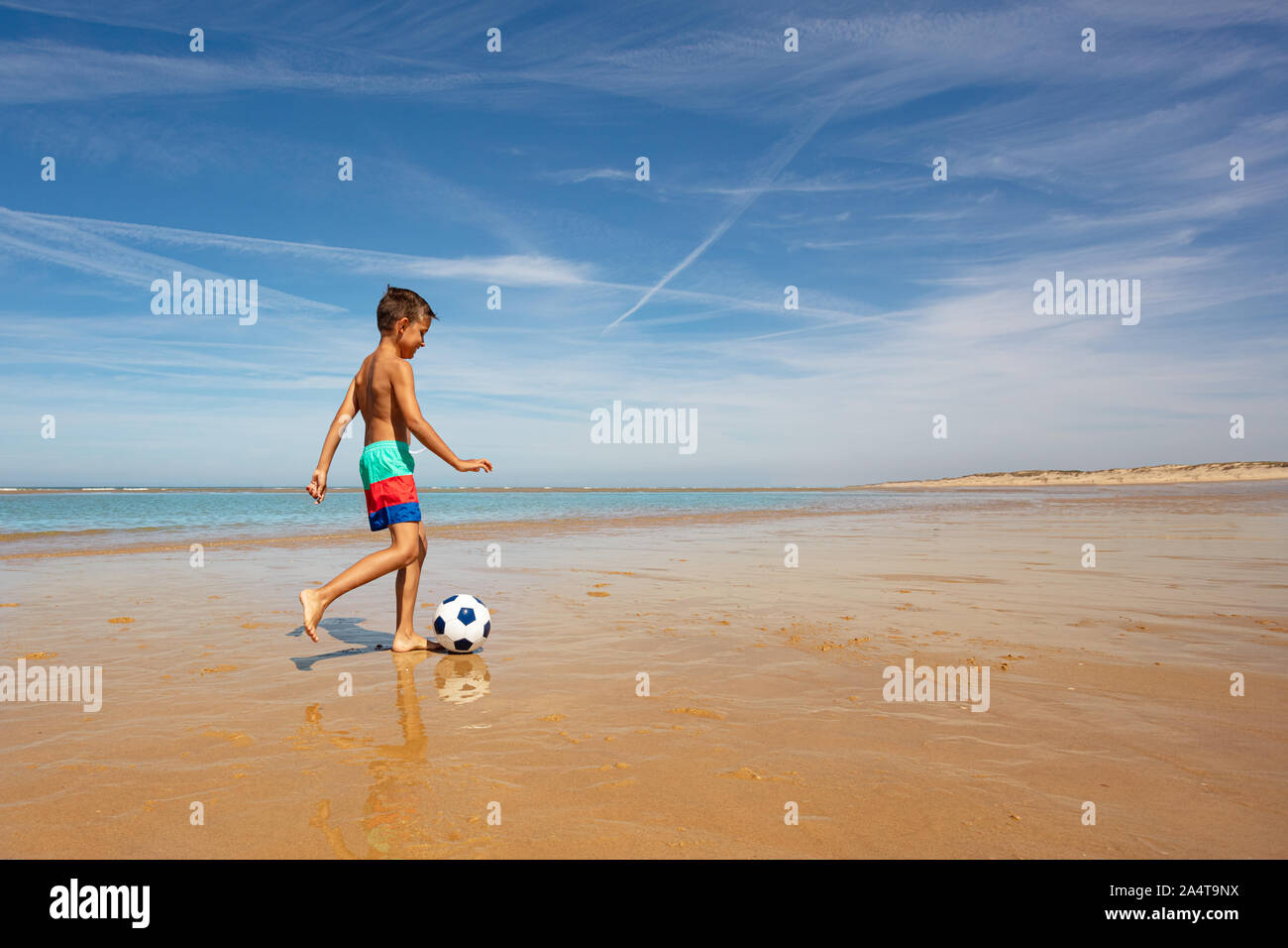 Happy boy play soccer ball on the beach near the sea water Stock Photo ...