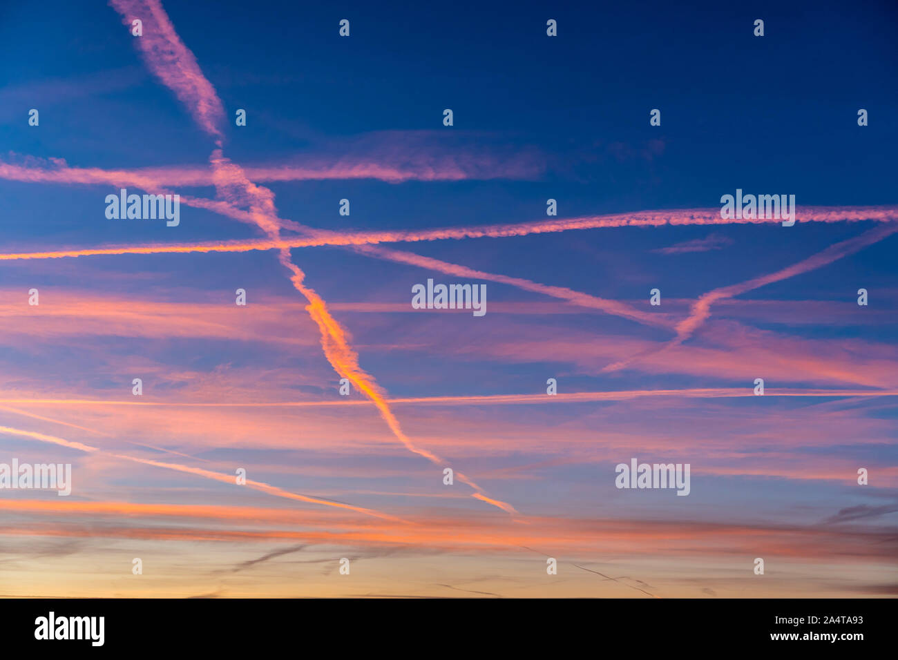 Texture of the sunset sky with red airplane trails Stock Photo - Alamy