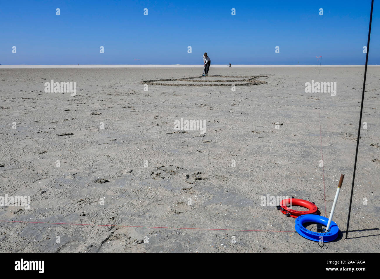 Creating sand drawings at beach in Holland Stock Photo - Alamy