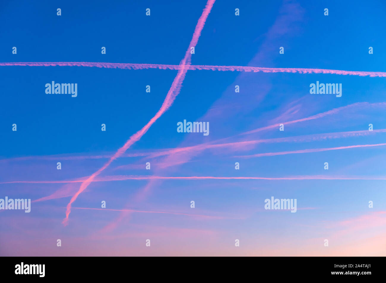 Texture of the sunset sky with red airplane trails Stock Photo - Alamy