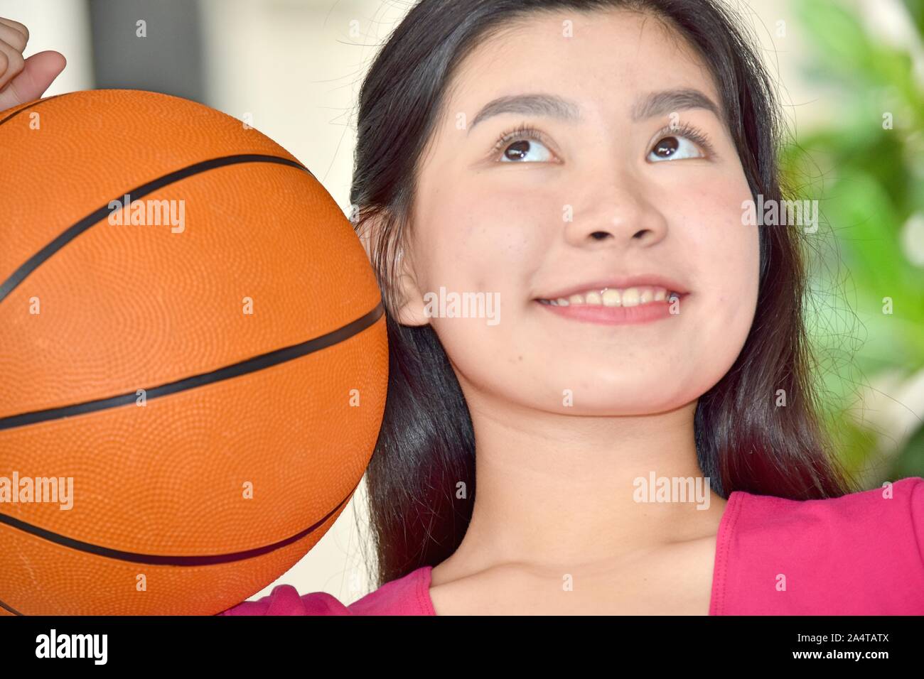 Smiling Fit Asian Female Basketball Player With Basketball Stock Photo ...