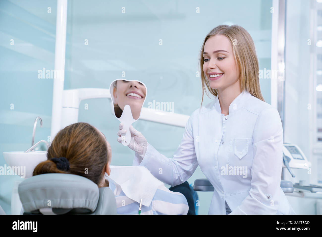 Patient of dentistry clinic lying in dentist chair and looking at ...