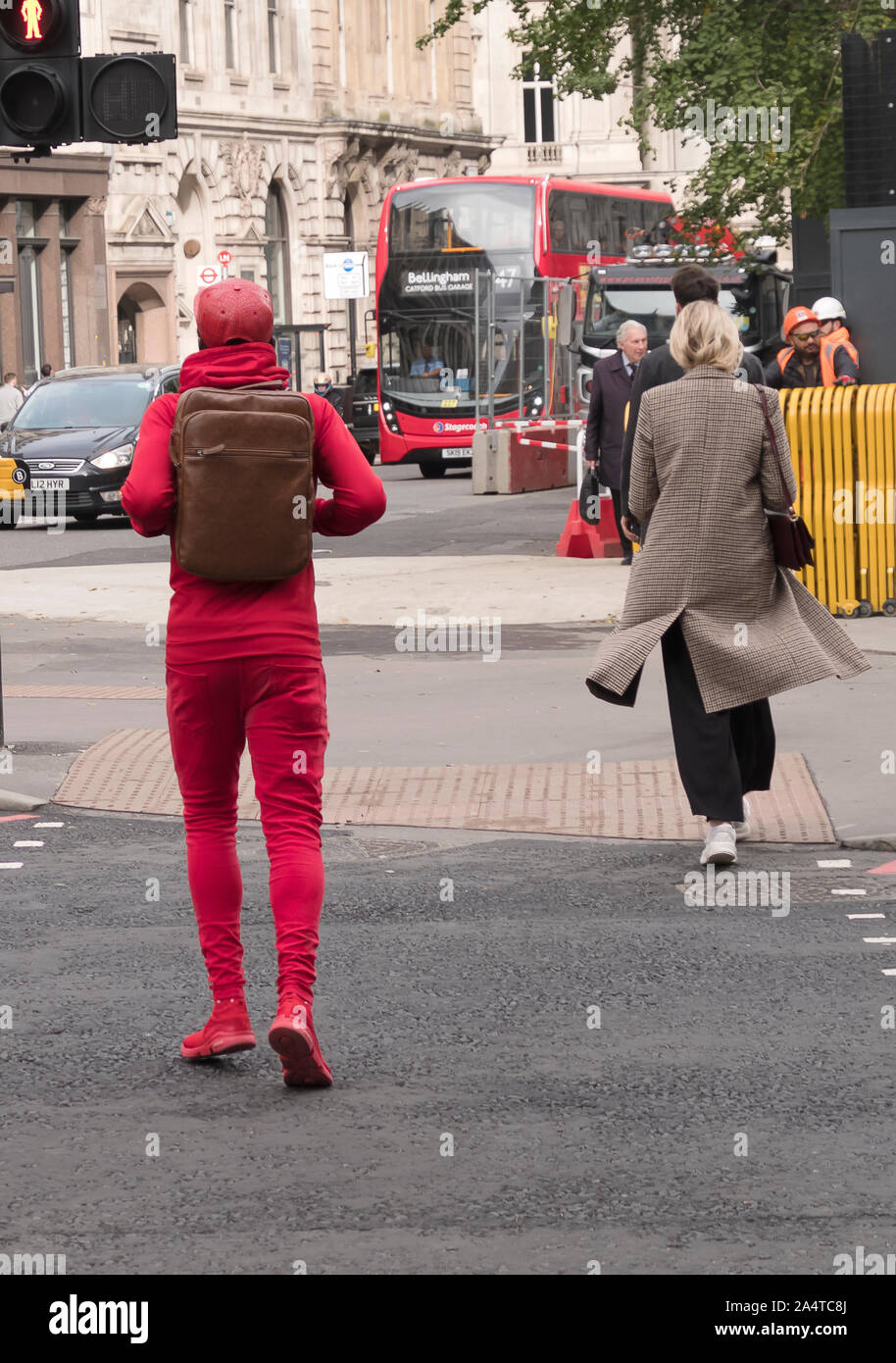 Man dressed completely in red walking through the streets in central ...
