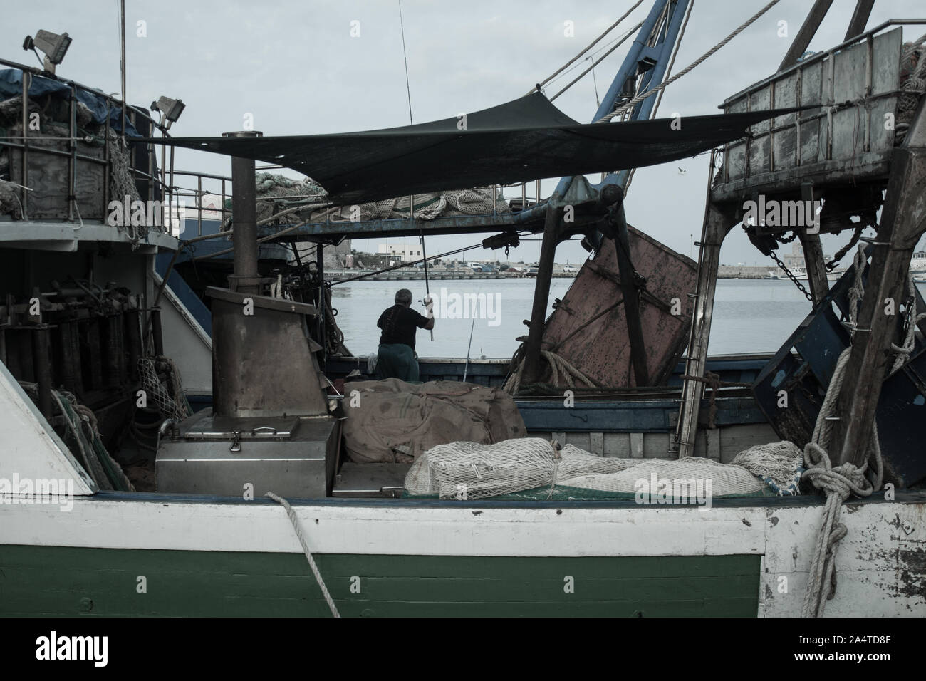 Fisher man catching fish at his boat Stock Photo - Alamy