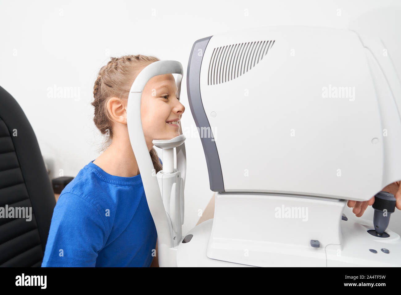 Side view of nice girl checking eye vision with diagnostic ...