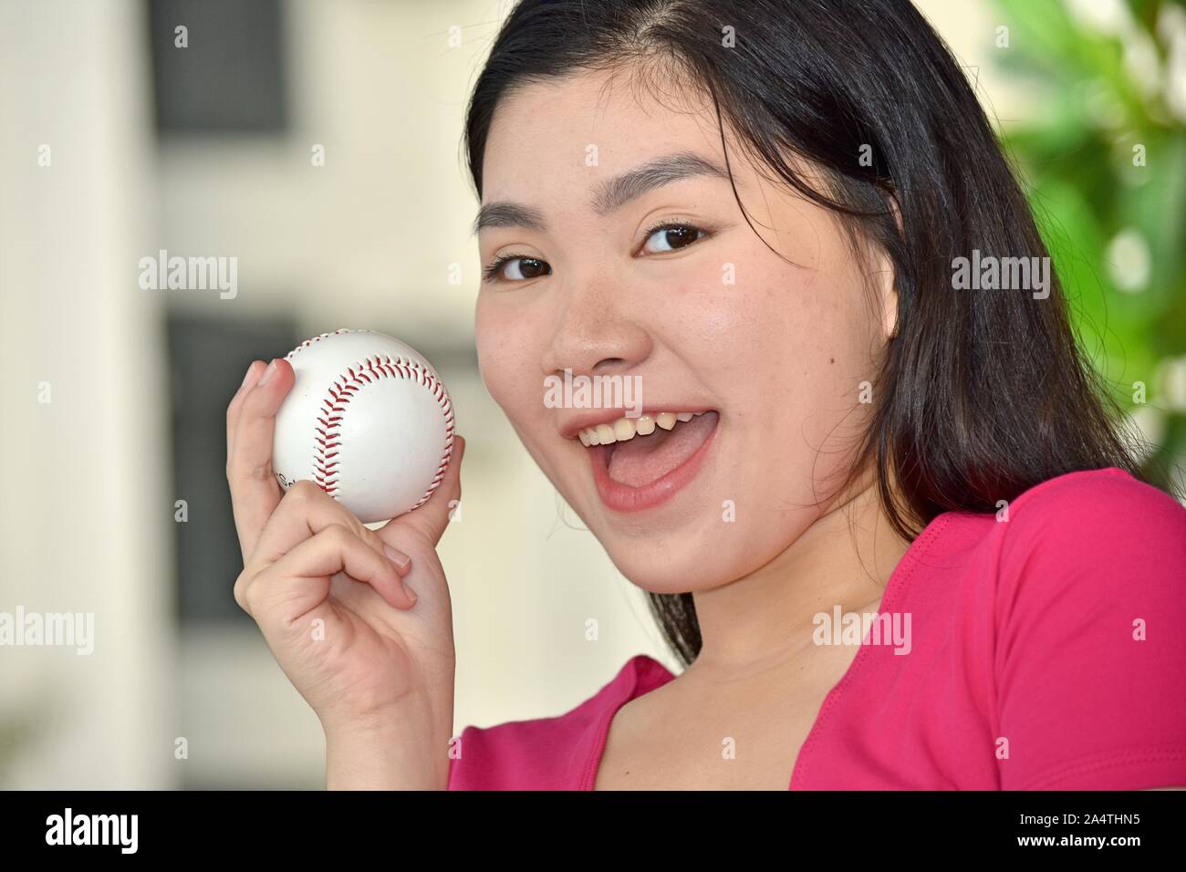 Chinese Female Baseball Player Smiling With Baseball Stock Photo - Alamy