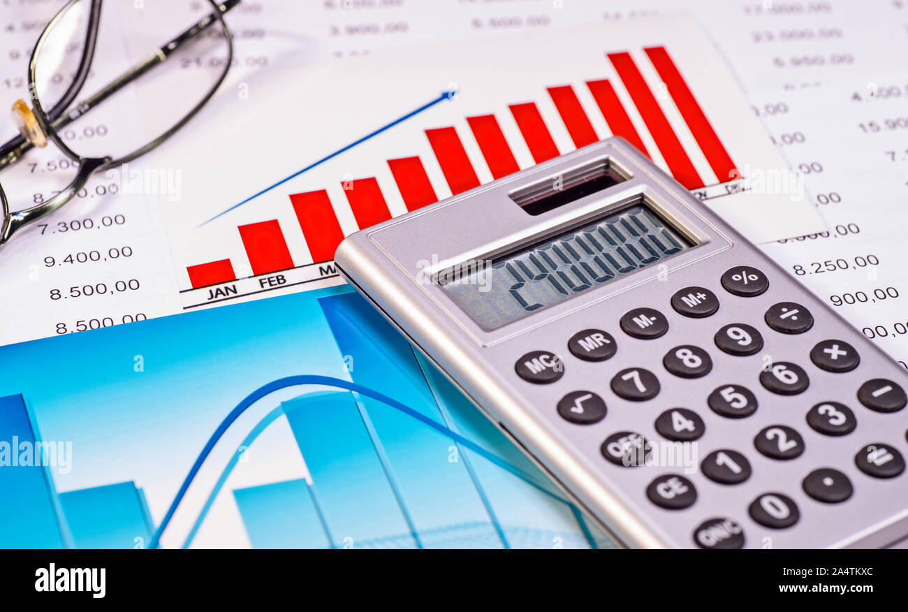 Diagrams and tables with calculator and glasses Stock Photo - Alamy