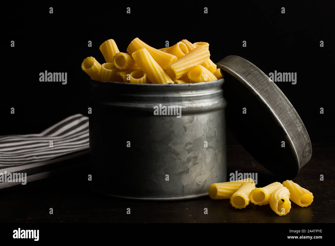 Raw macaroni in a galvanized can on a dark background Stock Photo - Alamy