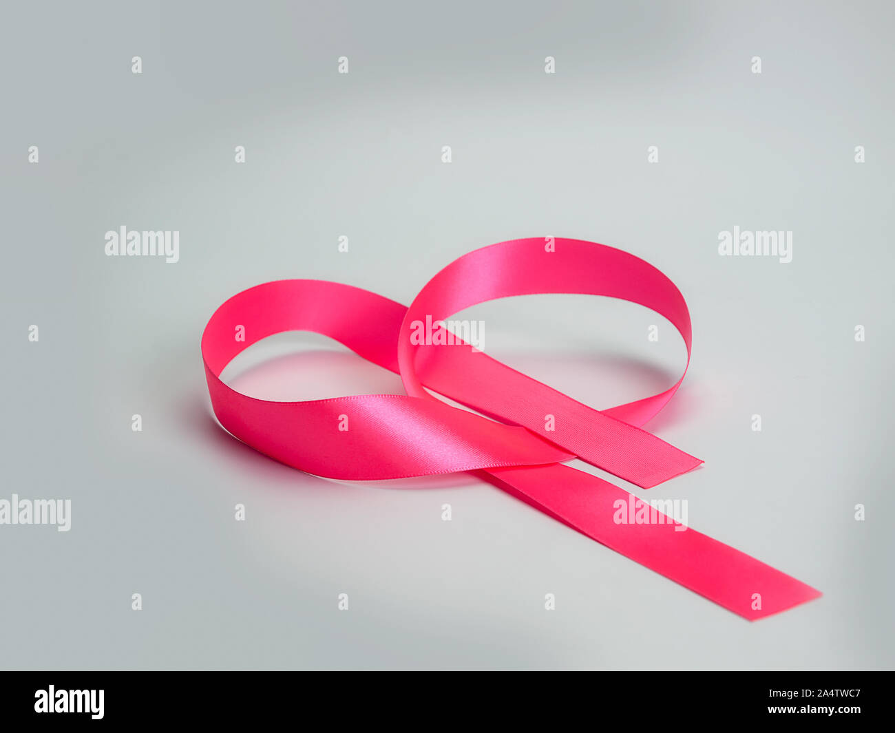 Pink ribbon on a white background Stock Photo - Alamy
