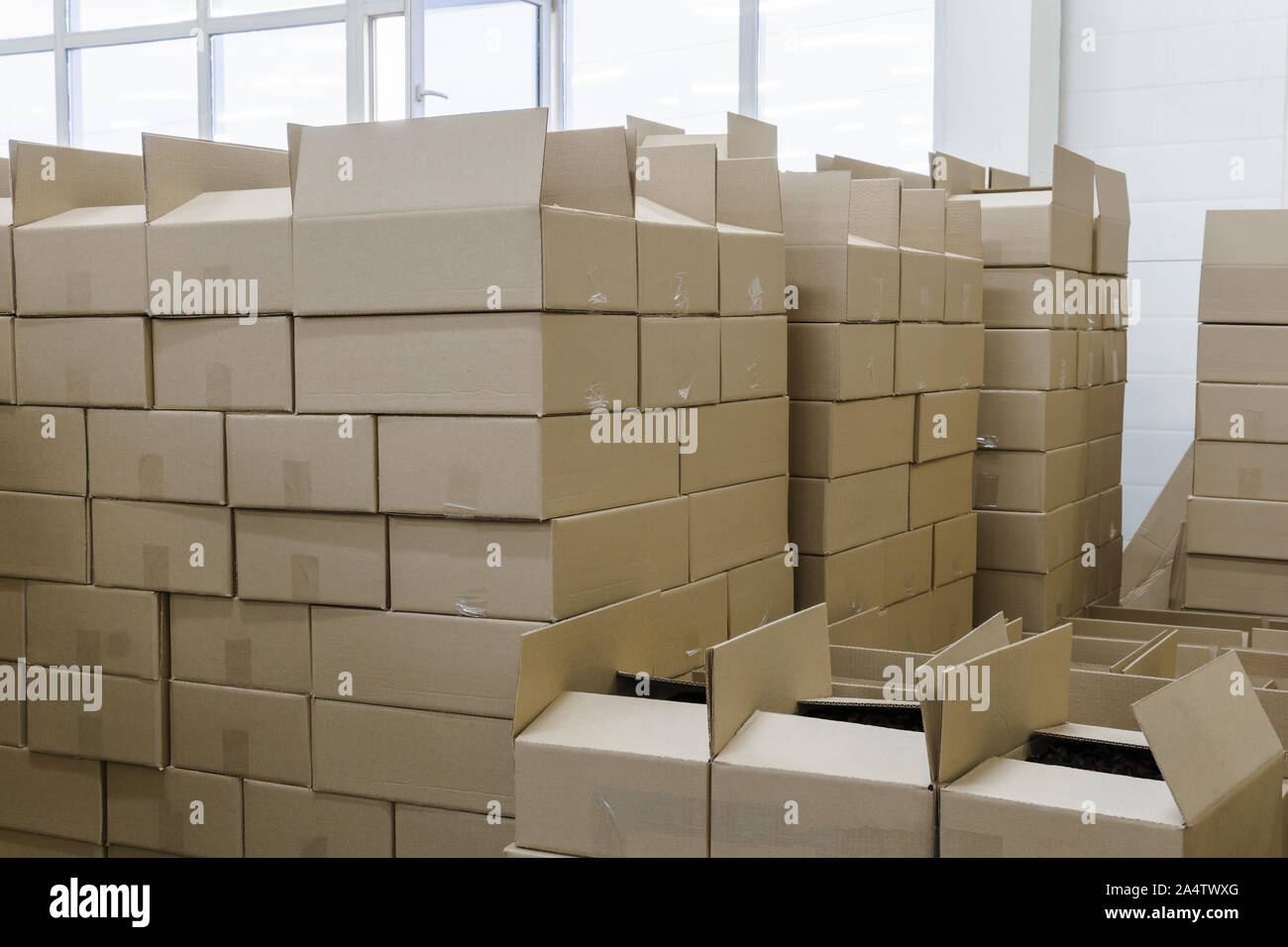 stacks of cardboard boxes with products in the packaging workshop Stock ...