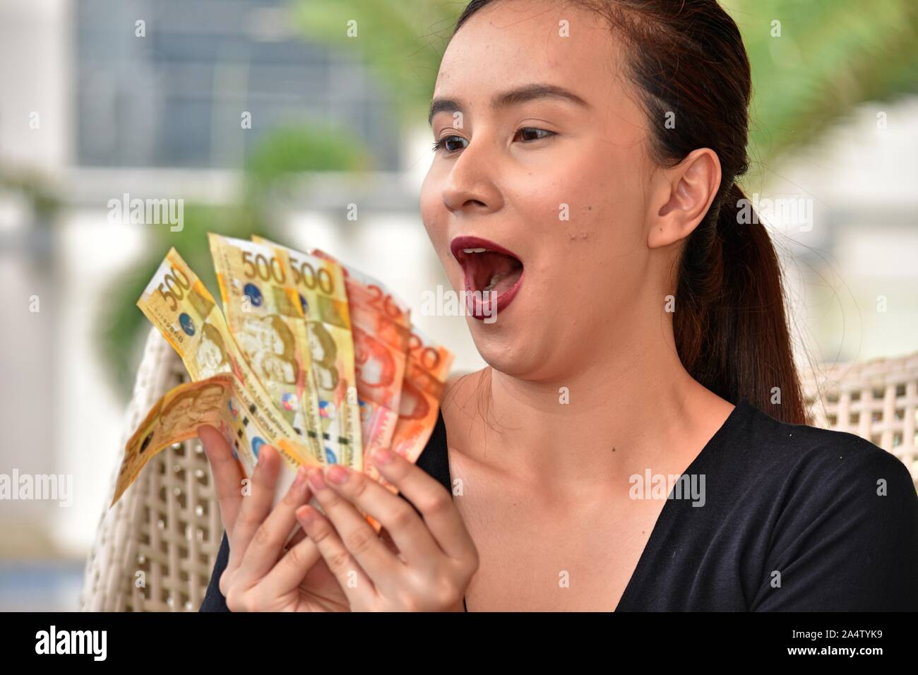 An Attractive Filipina Female Counting Money Stock Photo - Alamy