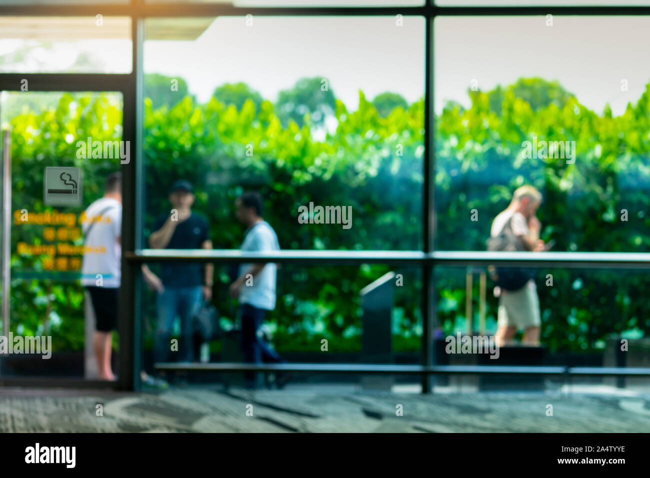 Blurred people smoking in smoking zone area of the mall or office. Four ...