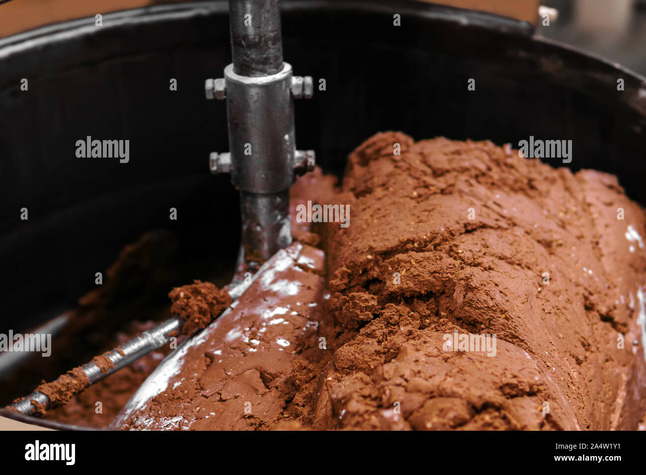 close-up of chocolate truffle filling in an industrial mixing machine ...