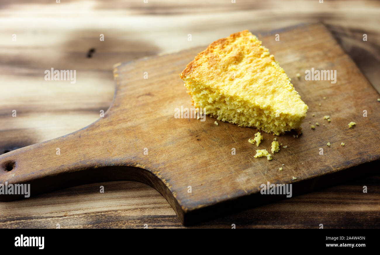 Single piece of cornbread on a small wooden cutting board Stock Photo ...