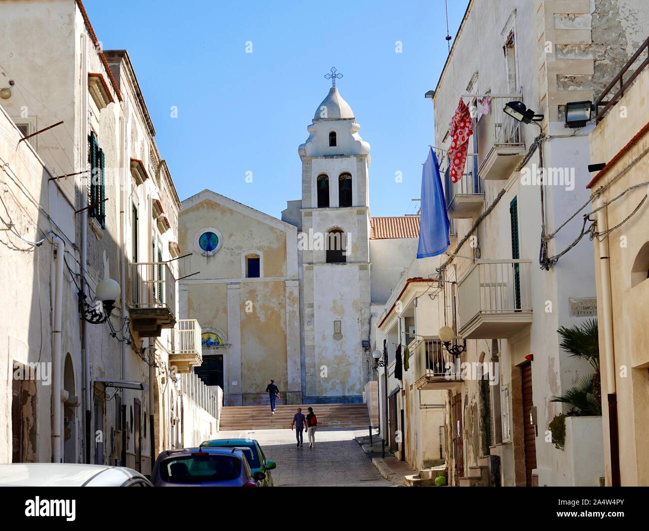 People and white stone buildings on street near the Church of San ...