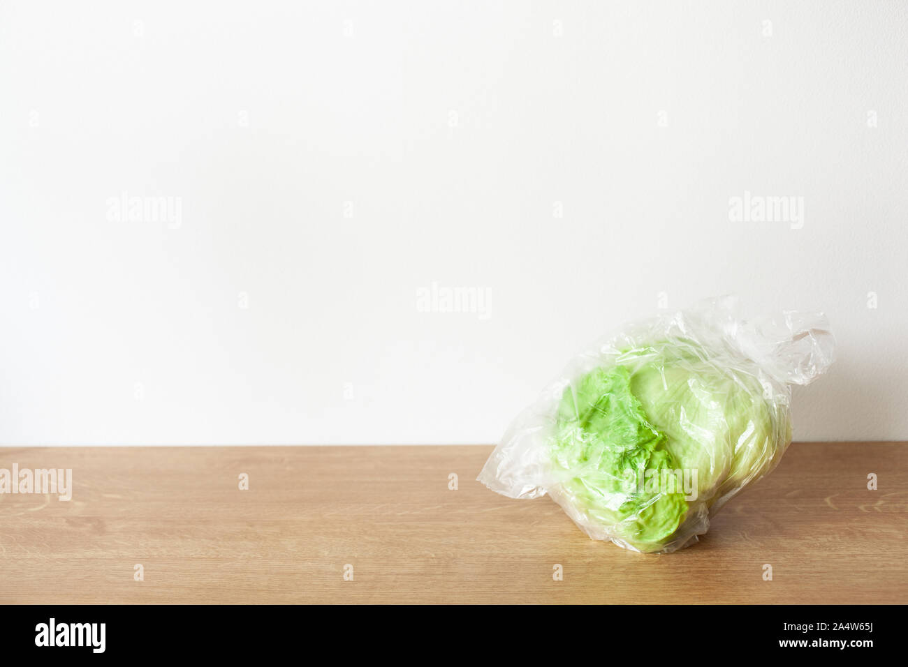 iceberg lettuce vegetable in plastic bag. single use plastic packaging ...