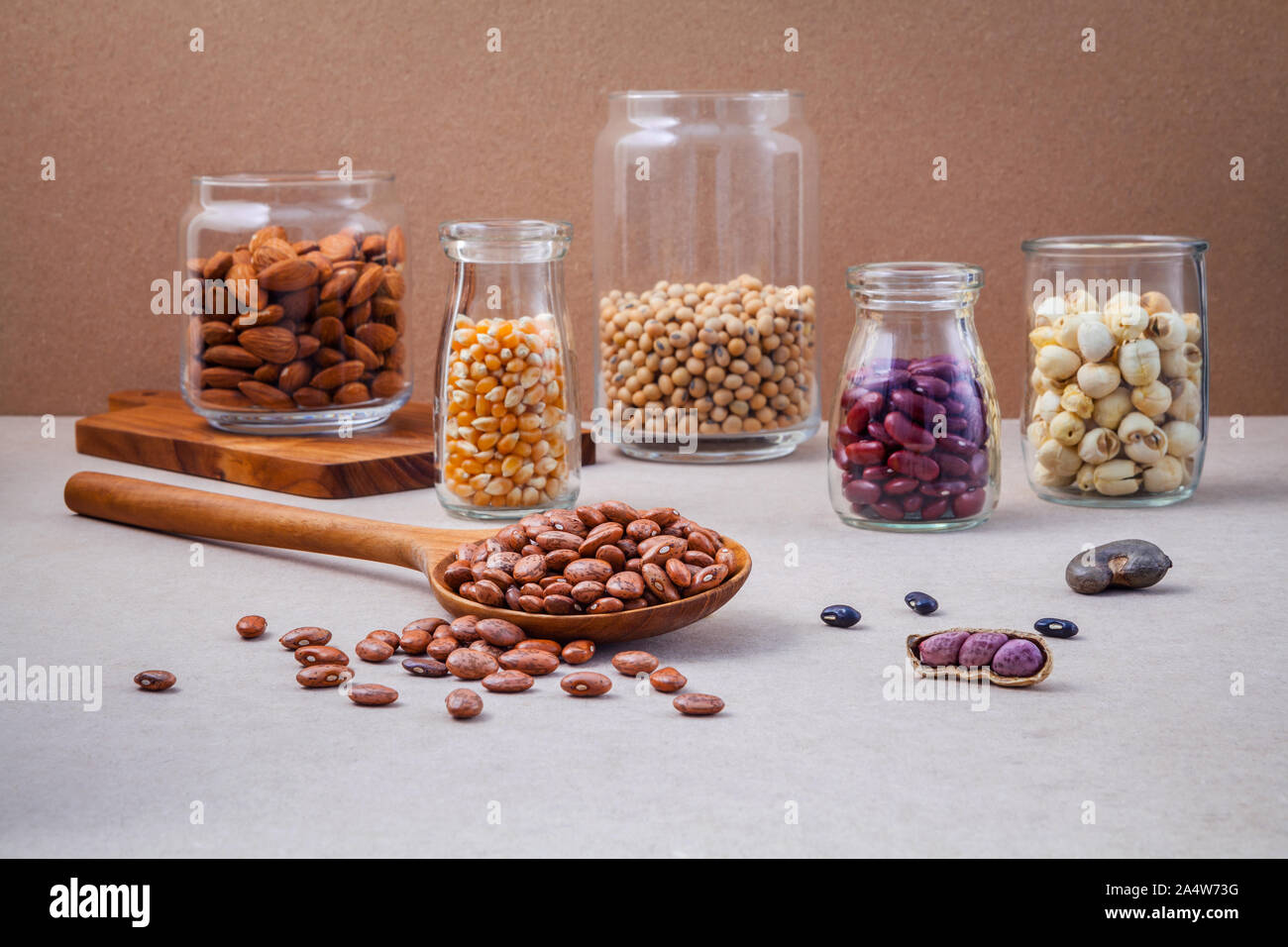 Various beans and nuts in the glass on brown background. mung bean ...