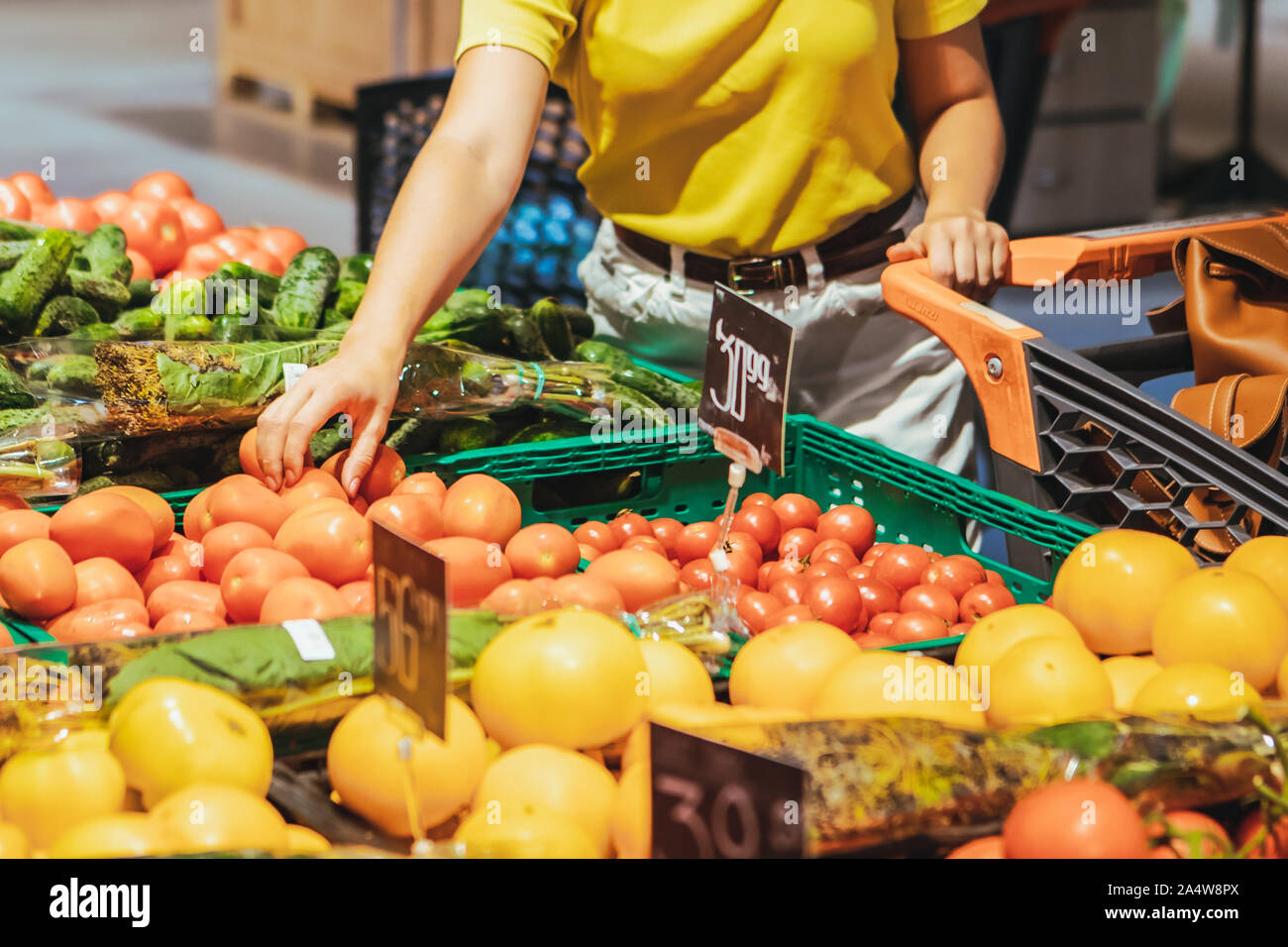 woman choosing red tomatoes from store shelf grocery shopping Stock ...