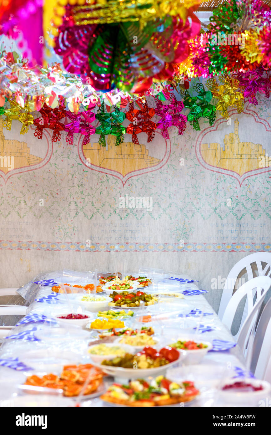 Colorful Sukkah decoration shiny garland and table. Happy family ...