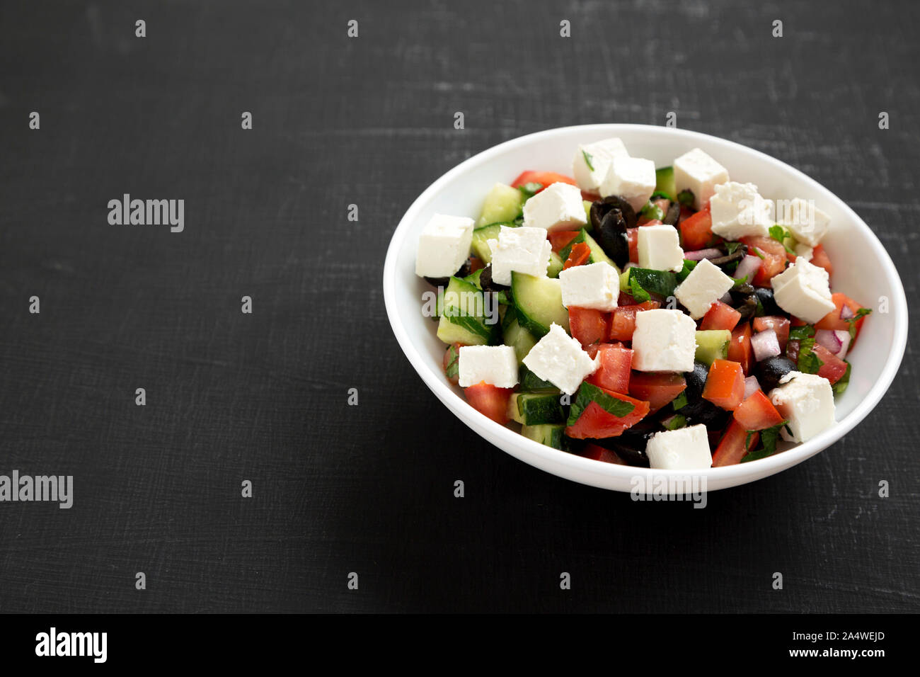 Homemade Shepherd's salad with cucumbers, parsley and feta in a white ...