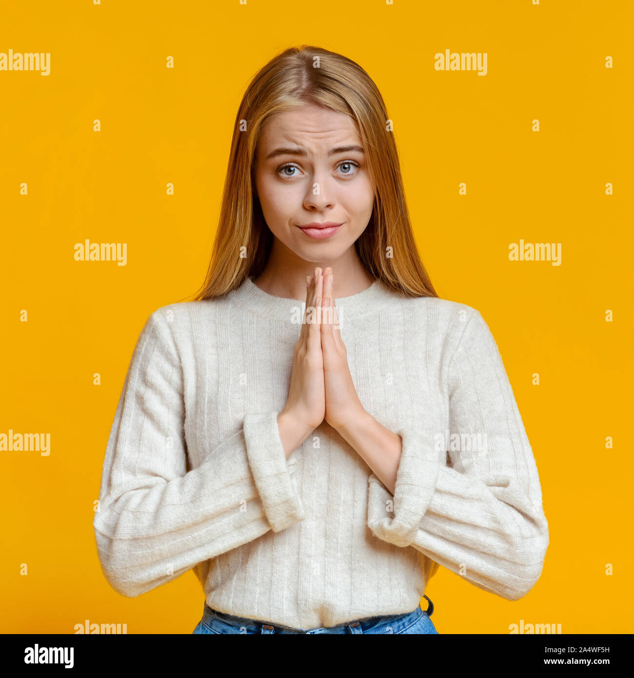 Beautiful millennial girl praying with hands clasped near face Stock ...
