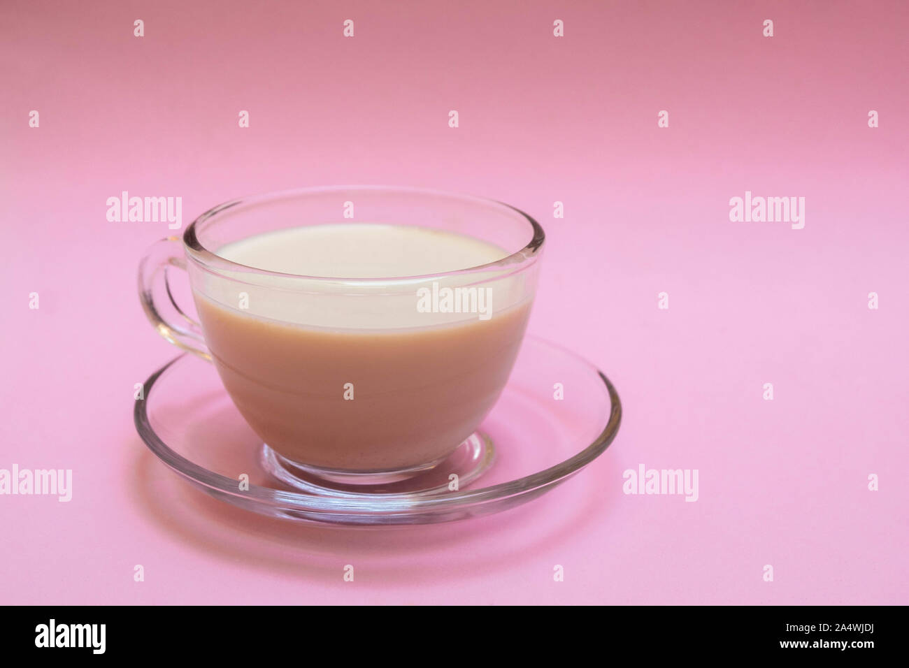 Indian milk tea (masala chai) in a glass cup on soft pink background ...