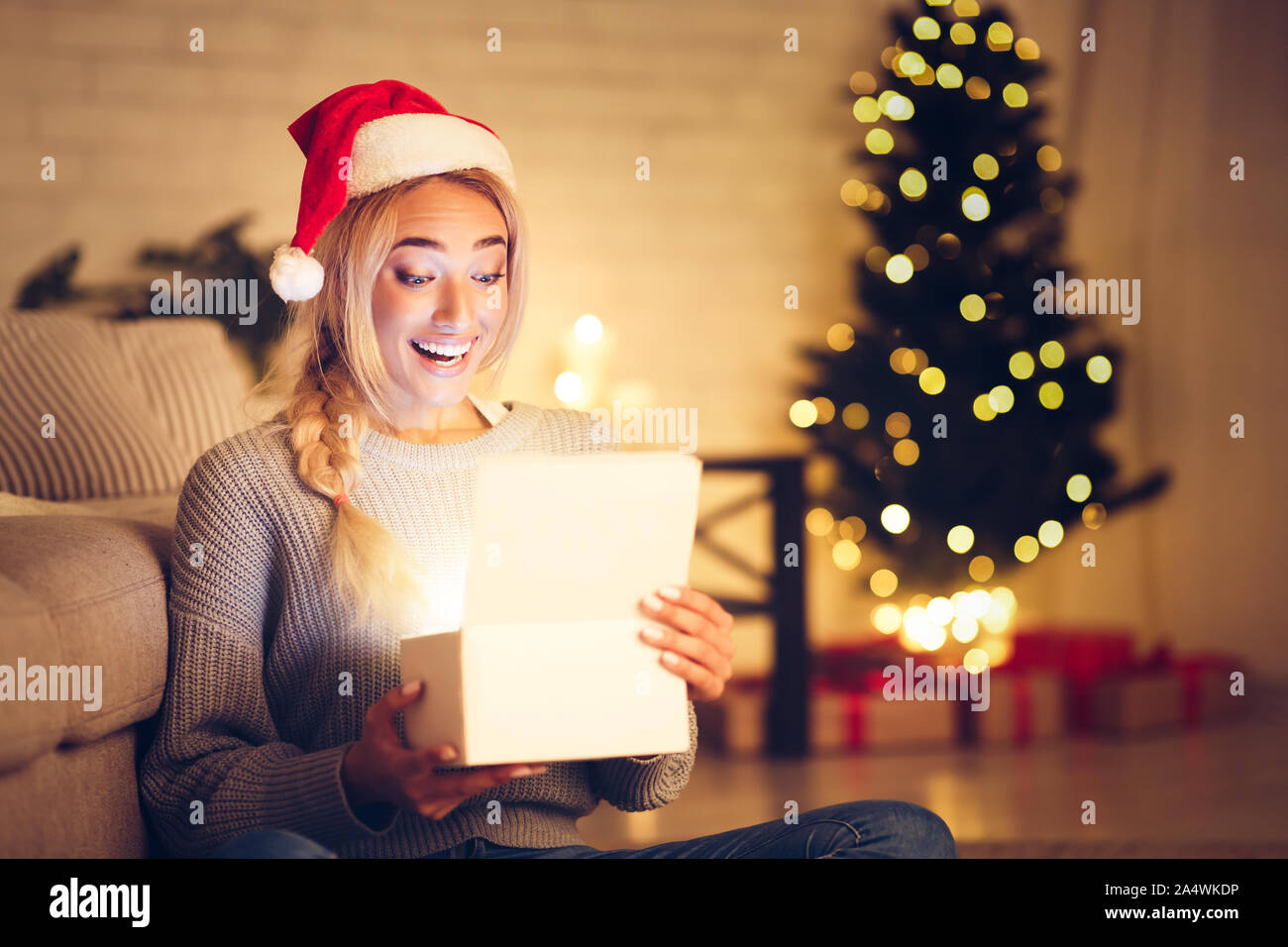 Christmas miracle. Surprised woman opening gift box Stock Photo - Alamy