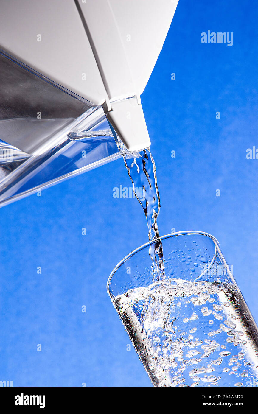 Water pouring from jug into clear glass Stock Photo - Alamy