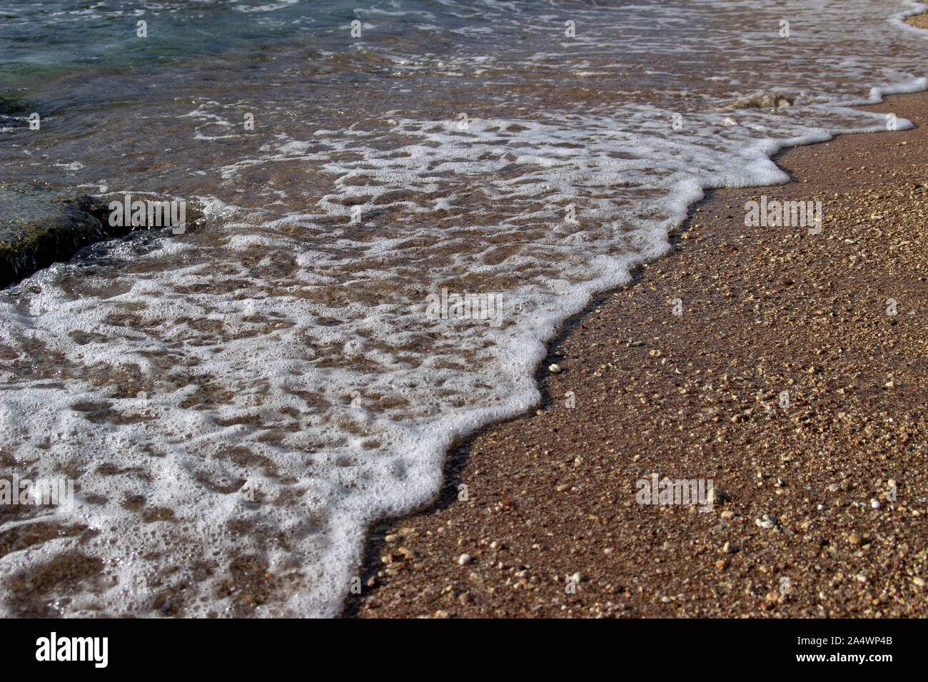 Summer background of hot sand with sea or ocean wave bubbles with copy ...