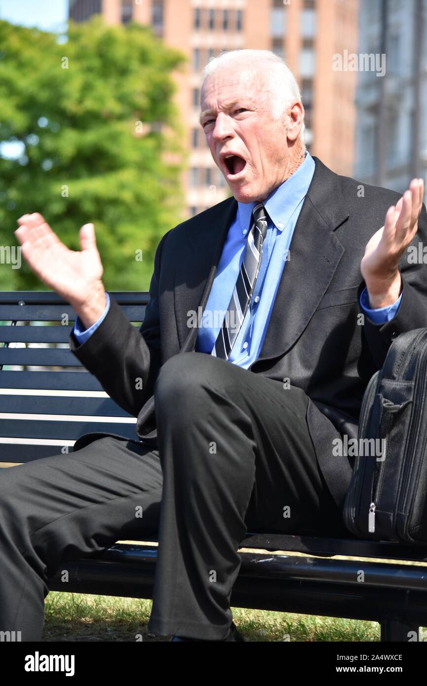 Angry Business Man Sitting On Bench Stock Photo - Alamy