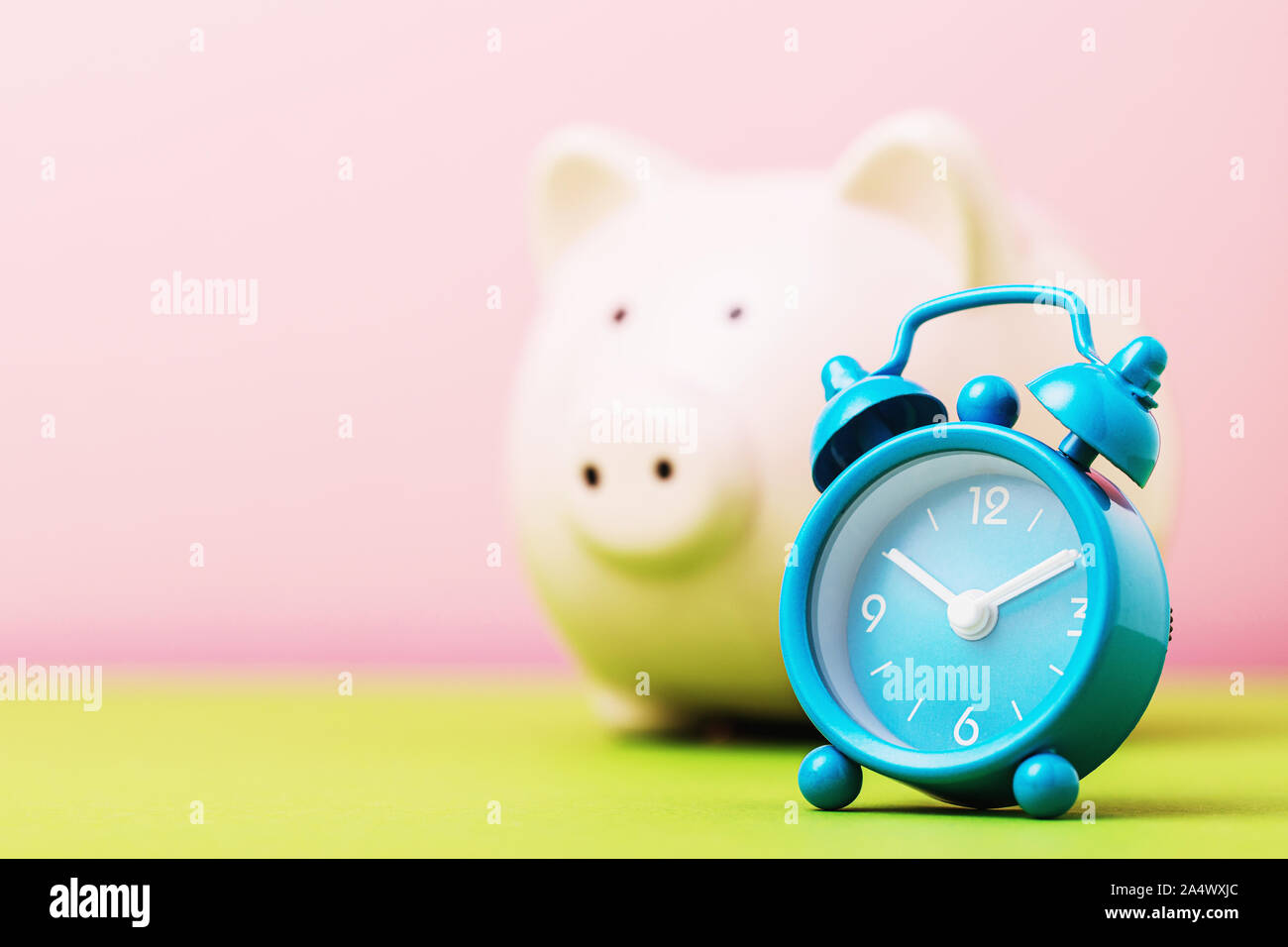 Alarm clock and piggy bank with copy space, close-up. Concept - time to ...