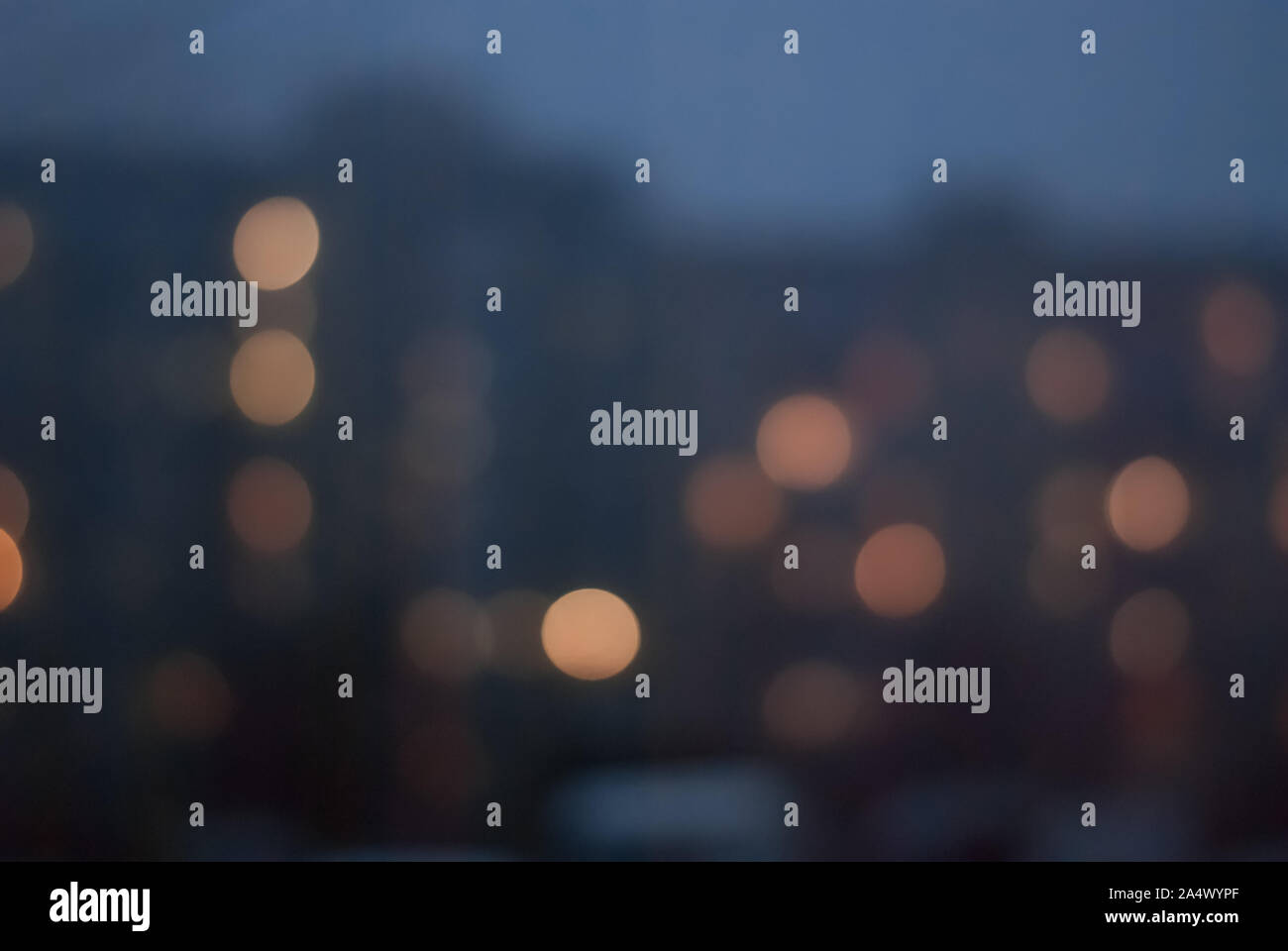 Blurred background of evening cityscape with luminous windows in houses ...