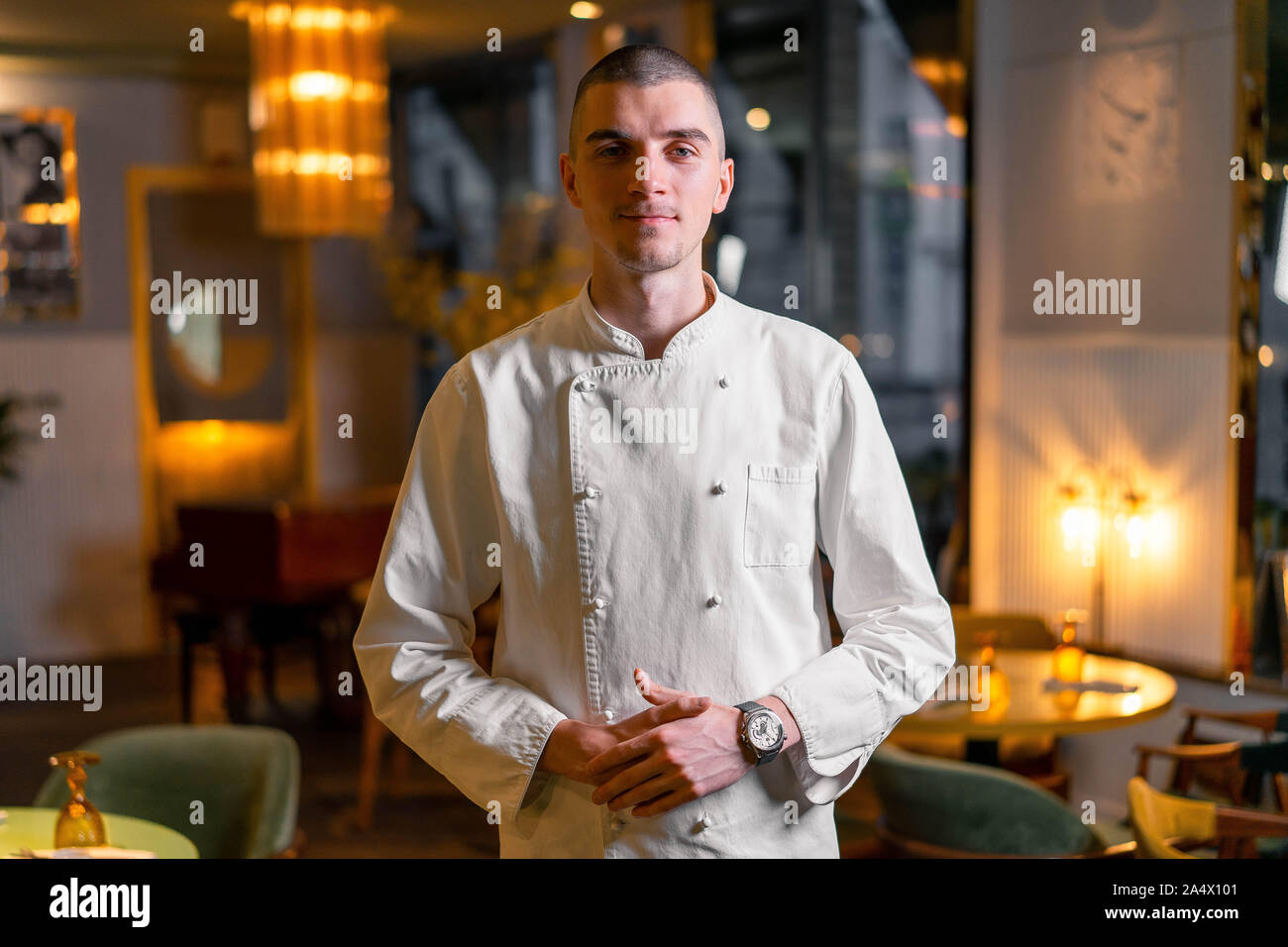 Young brutal handsome cook chief posing in modern luxury restaurant ...