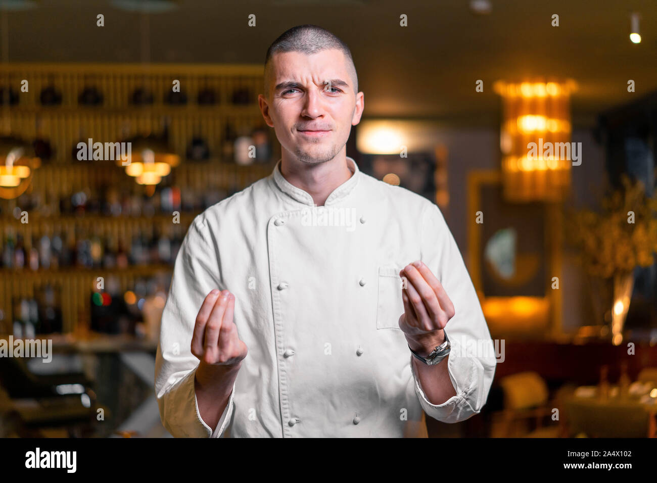 Young brutal handsome cook chief posing in modern luxury restaurant ...